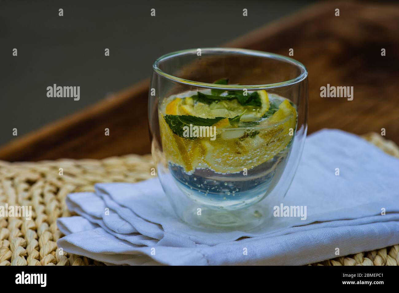 Tasty gin and tonic cocktail with slices of lemon and fresh mint on ...