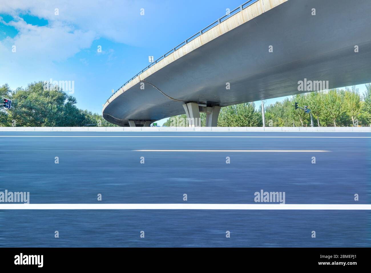 Under the overpass, car-free asphalt road, modern city building skyline ...