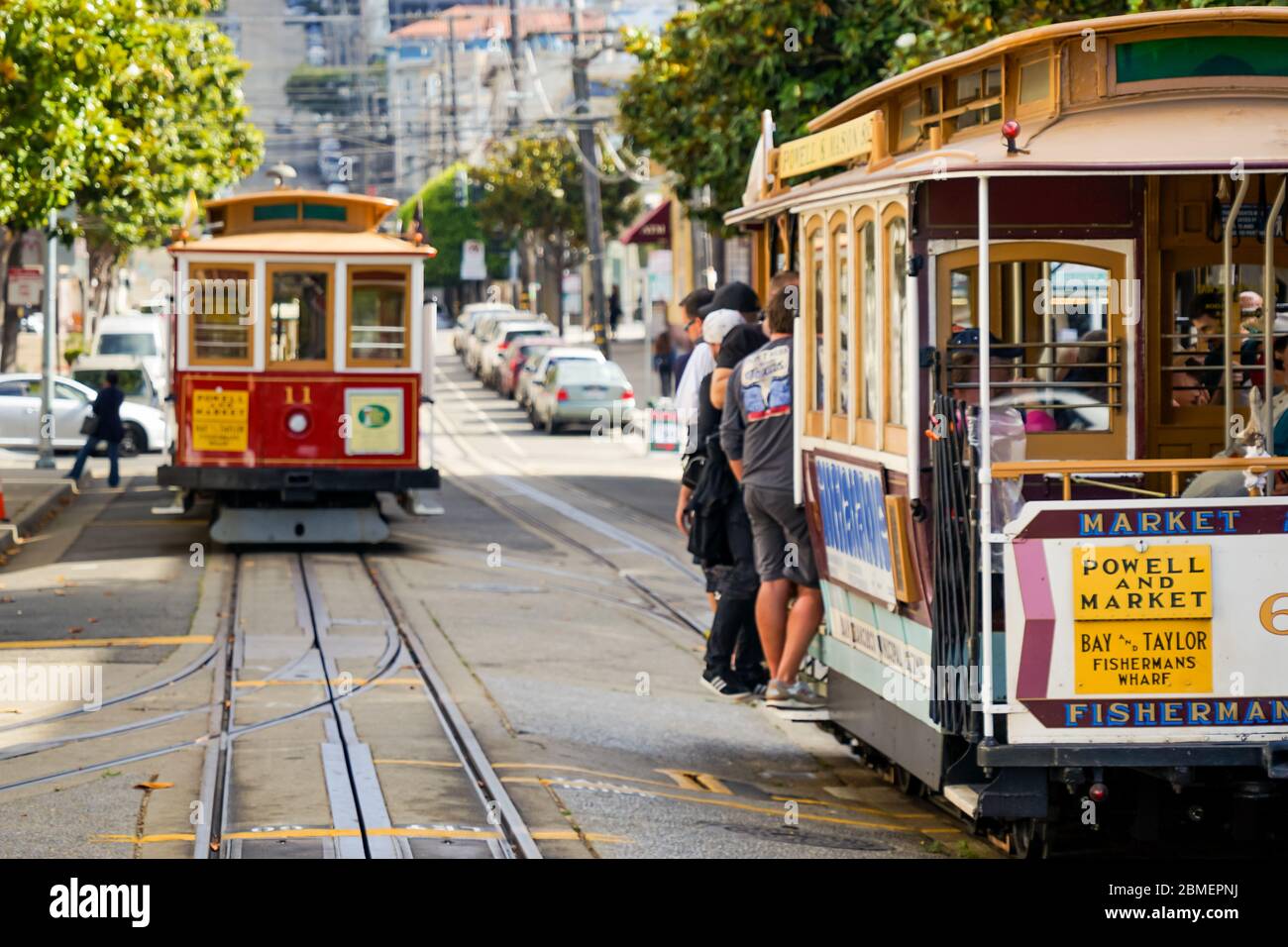 Vintage cable cars with passengers hanging on outside in San Francisco ...