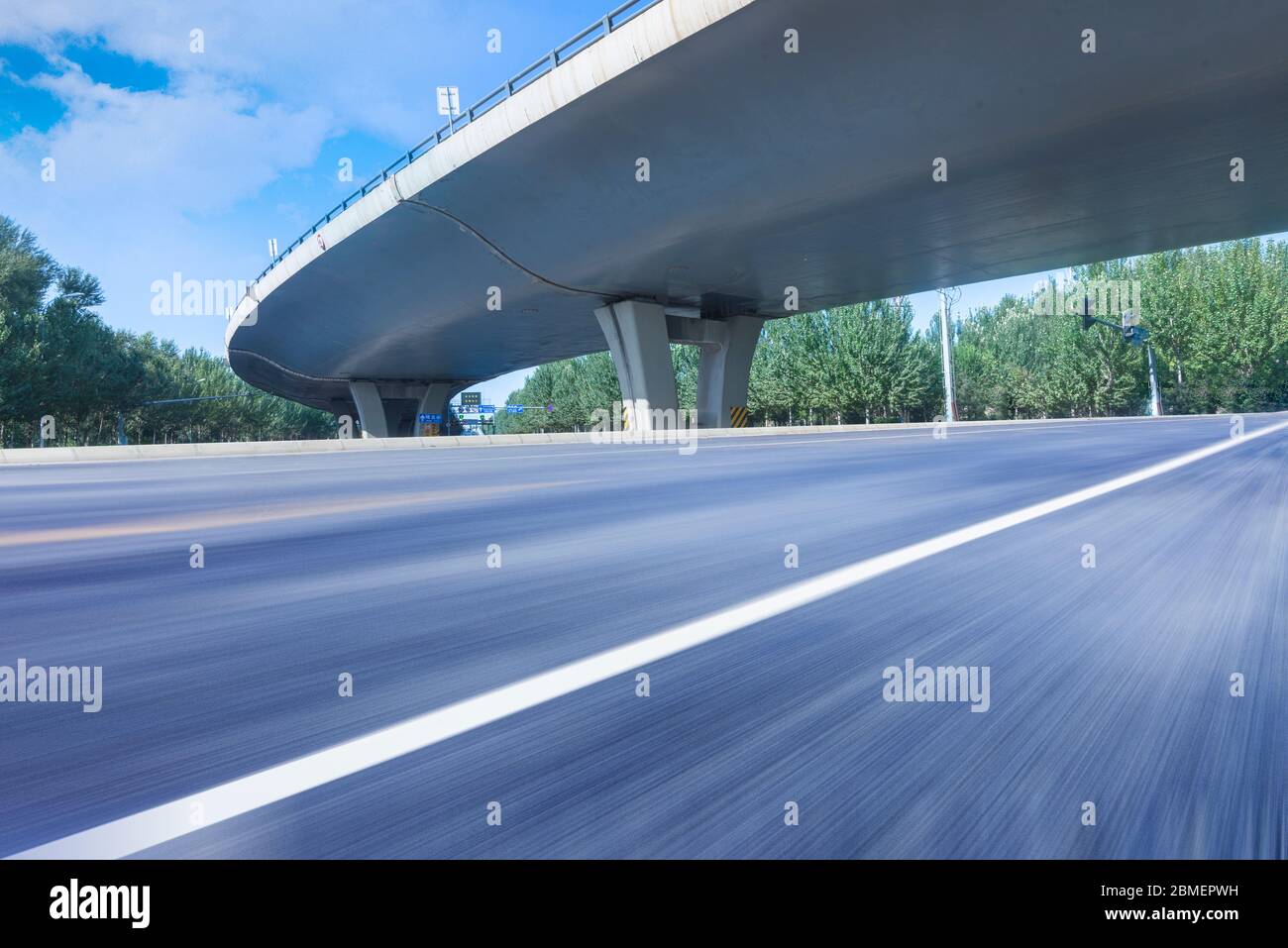 Under the overpass, car-free asphalt road, modern city building skyline ...