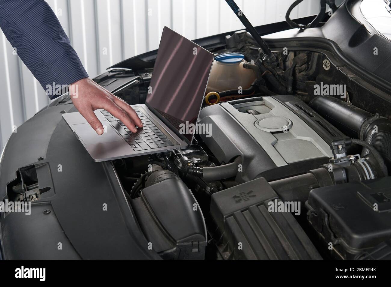 Car mechanic using computer in auto repair shop Stock Photo - Alamy