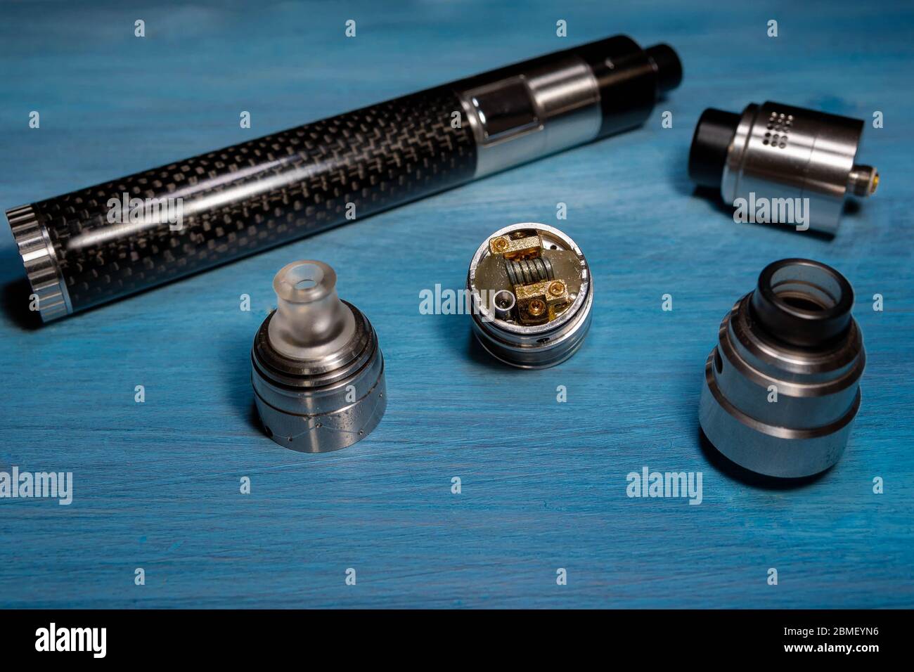 black electronic cigarette and atomizer on a blue table Stock Photo - Alamy