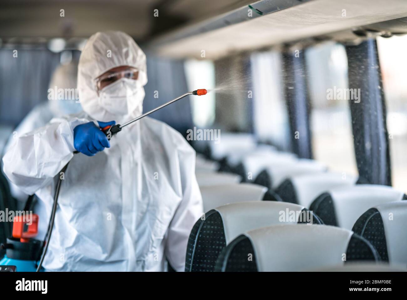 Specialist spraying disinfectant sanitize bus hi-res stock photography ...