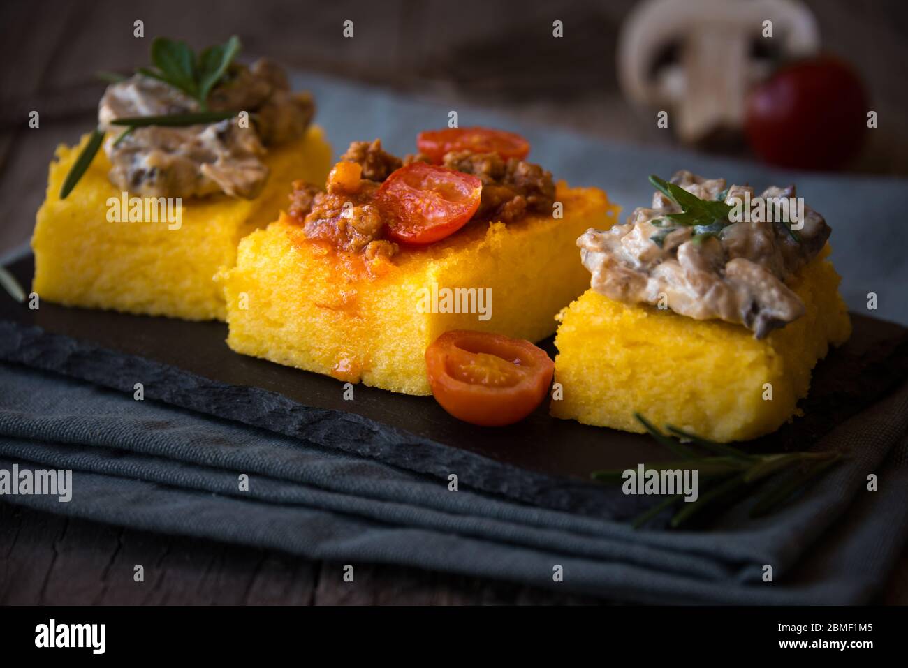 Slices of fried polenta with tomato sauce Stock Photo - Alamy