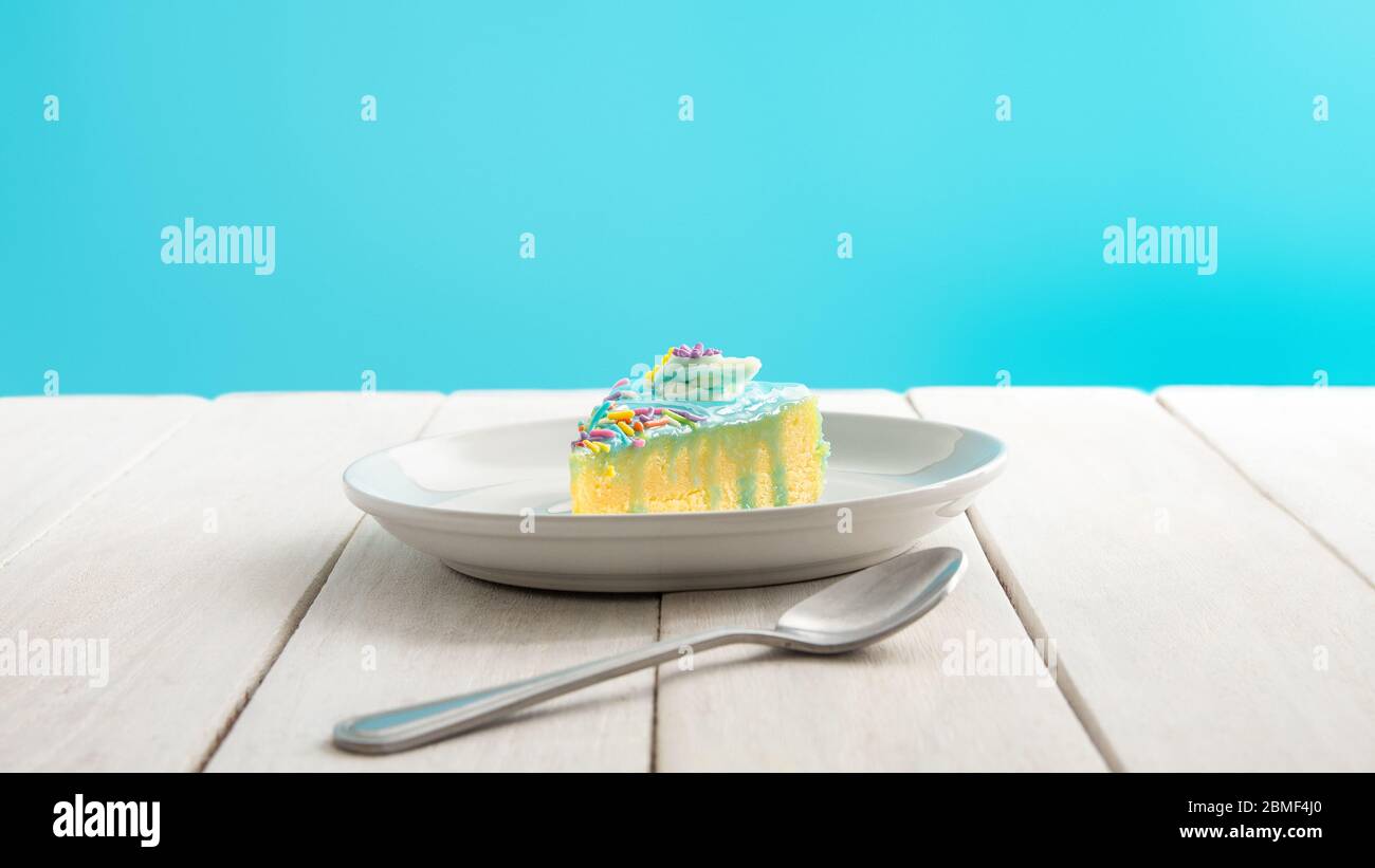 A slice of colorful sponge cake with confetti sprinkles a spoon ...