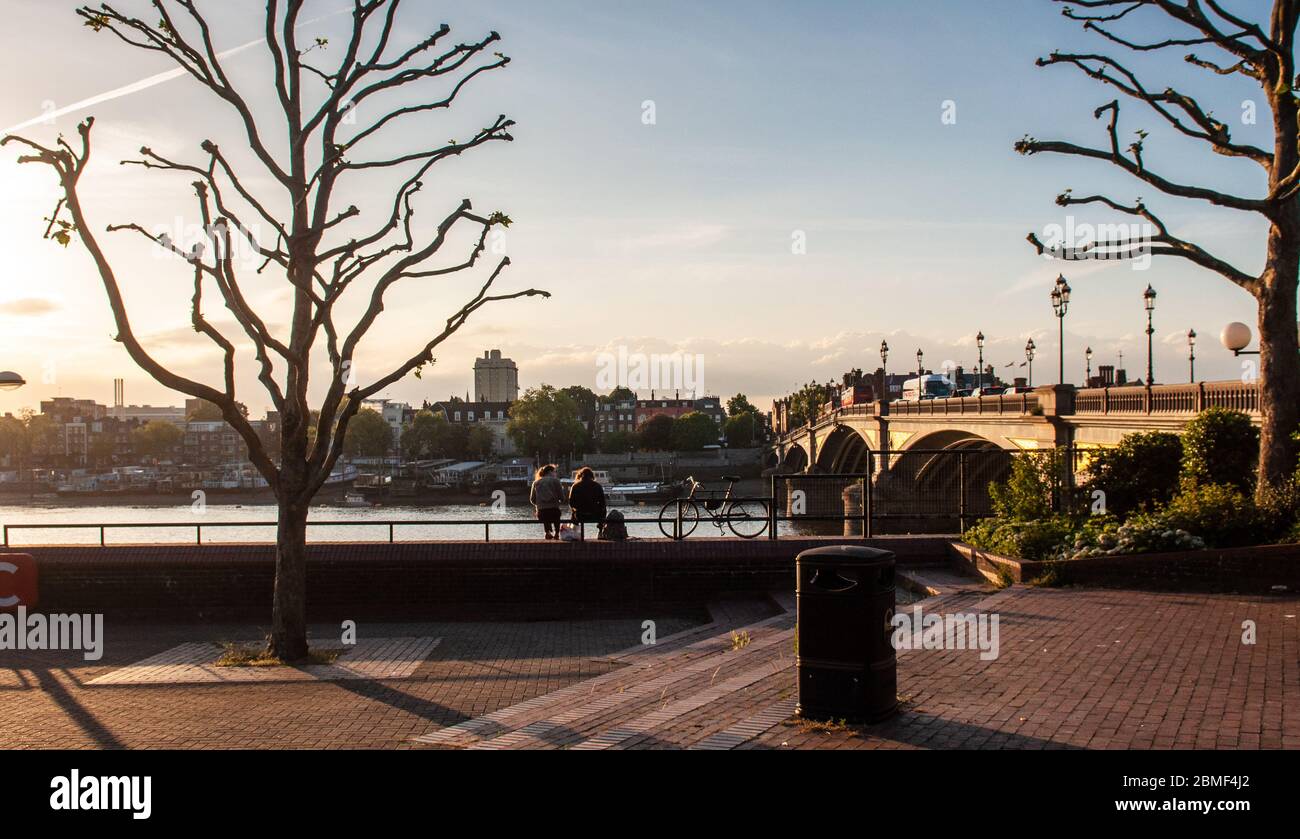 London, England, UK - June 5, 2013: A couple sit on a wall on the River ...