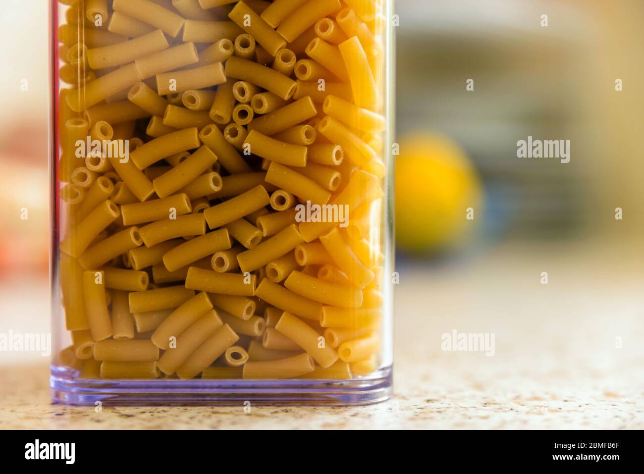 raw italian macaroni pasta inside clear storage container Stock Photo ...