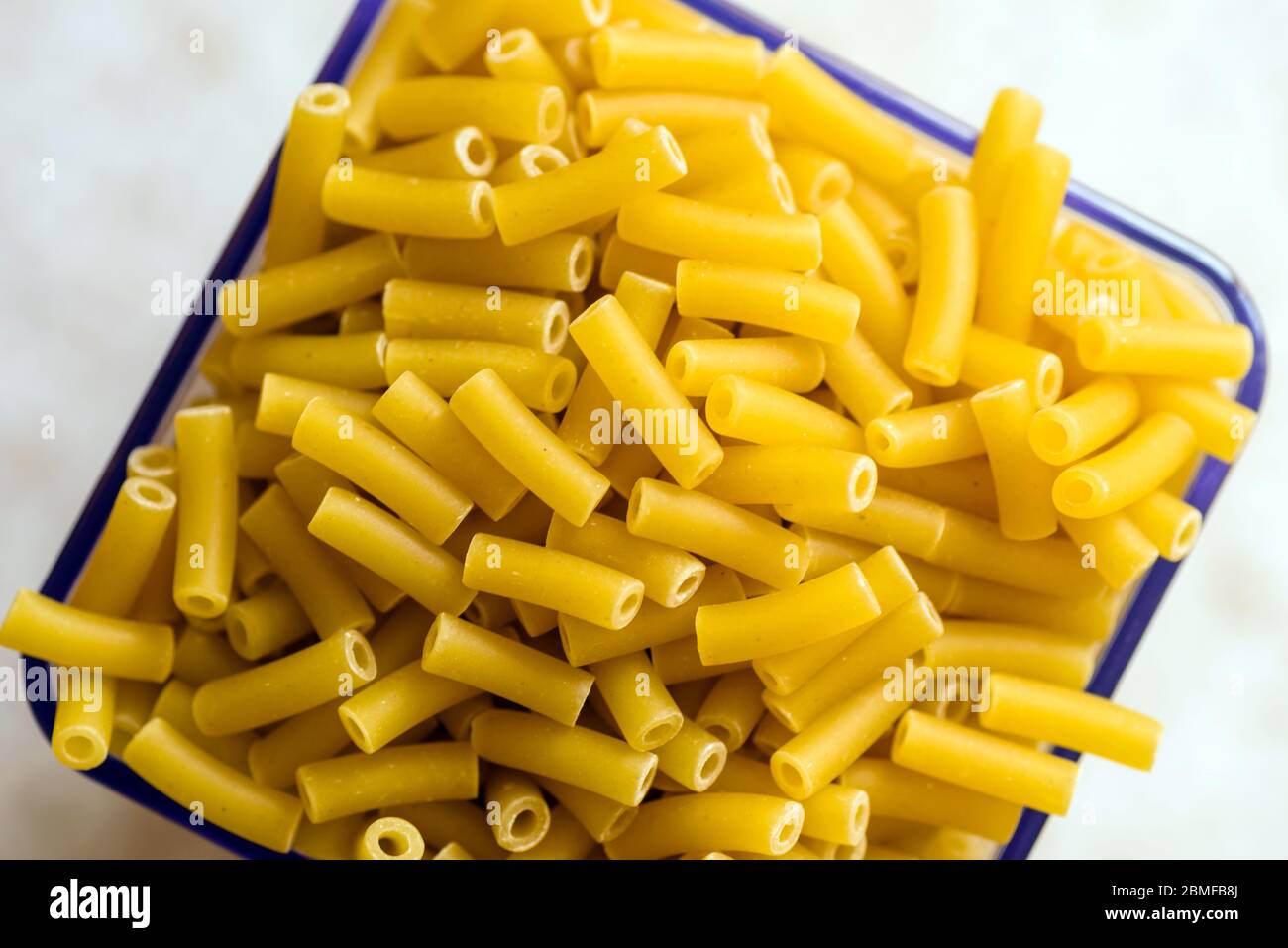 raw italian macaroni pasta inside clear storage container Stock Photo ...