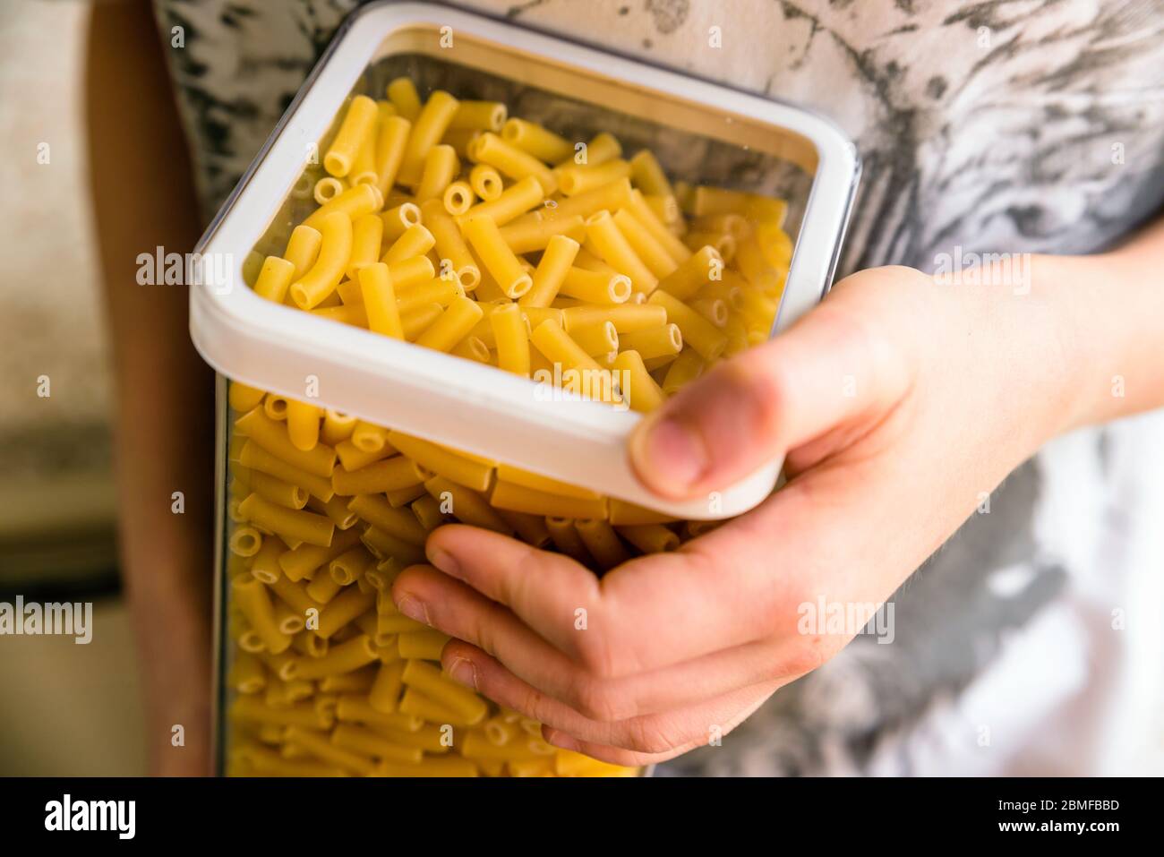 raw italian macaroni pasta inside clear storage container inside childs ...
