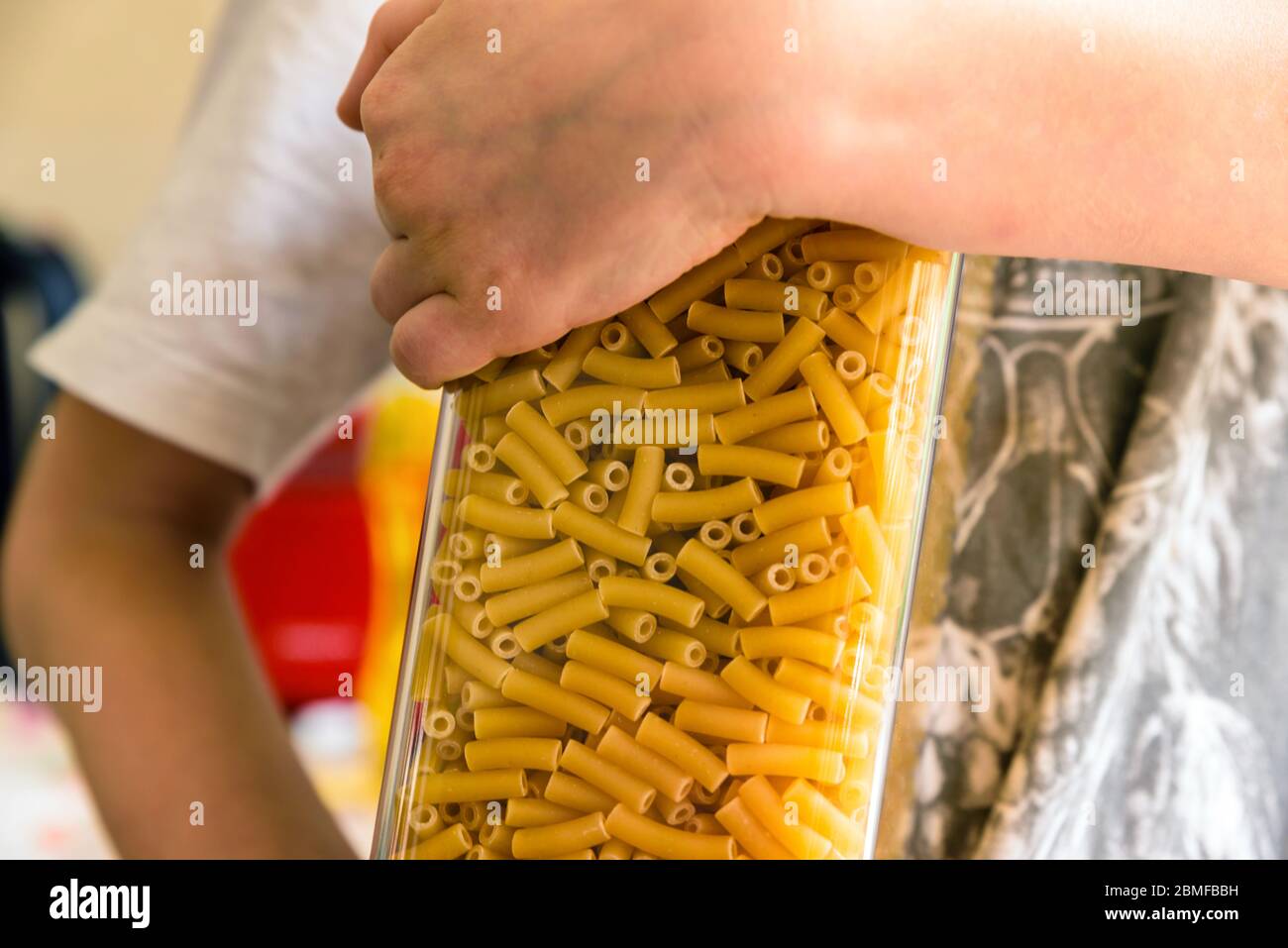 raw italian macaroni pasta inside clear storage container inside childs ...