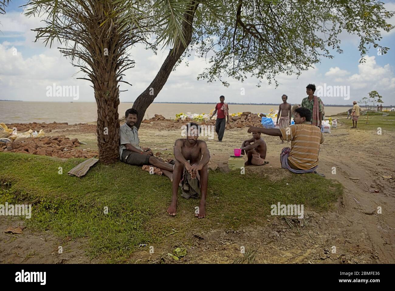 Workers getting a rest below a tree during a river erosion control ...