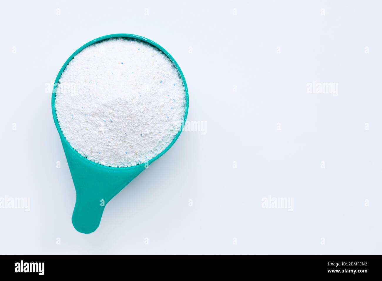 Measuring scoop with laundry powder on white background. Copy space ...