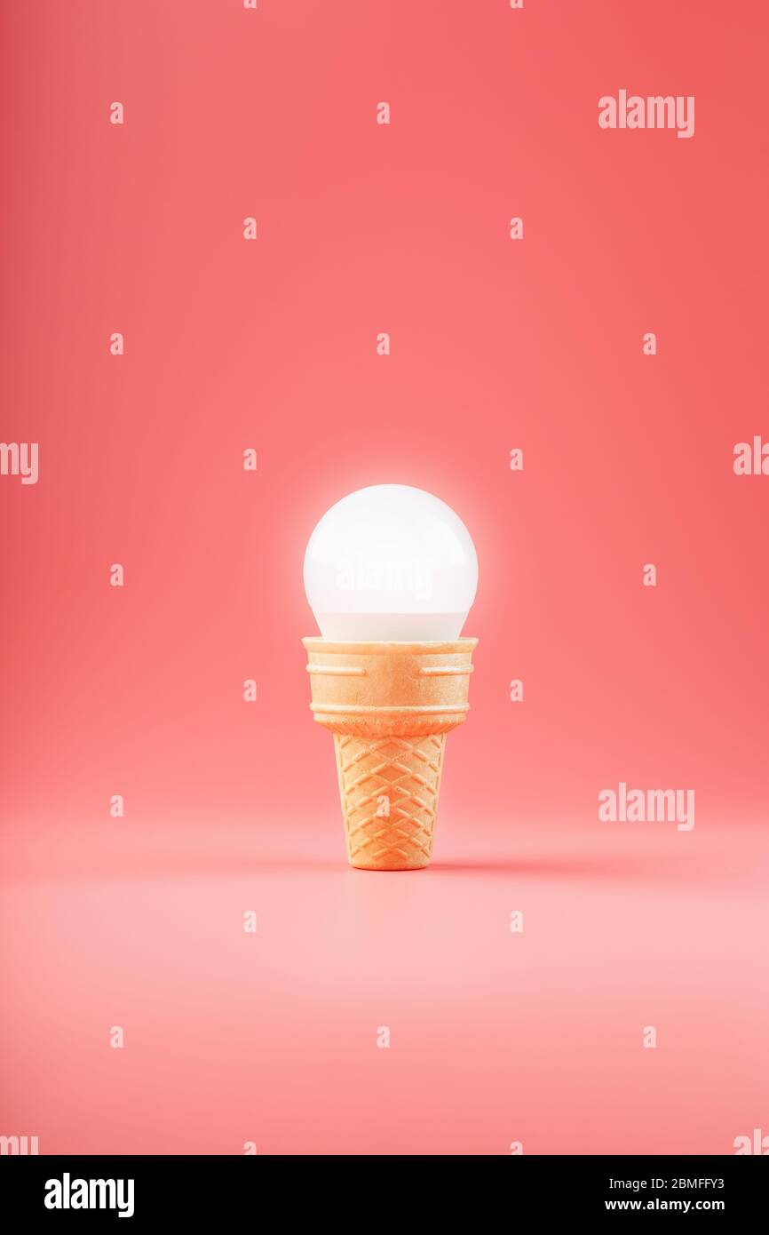 Light bulb ice cream in a waffle Cup on a pink background. Minimalistic ...