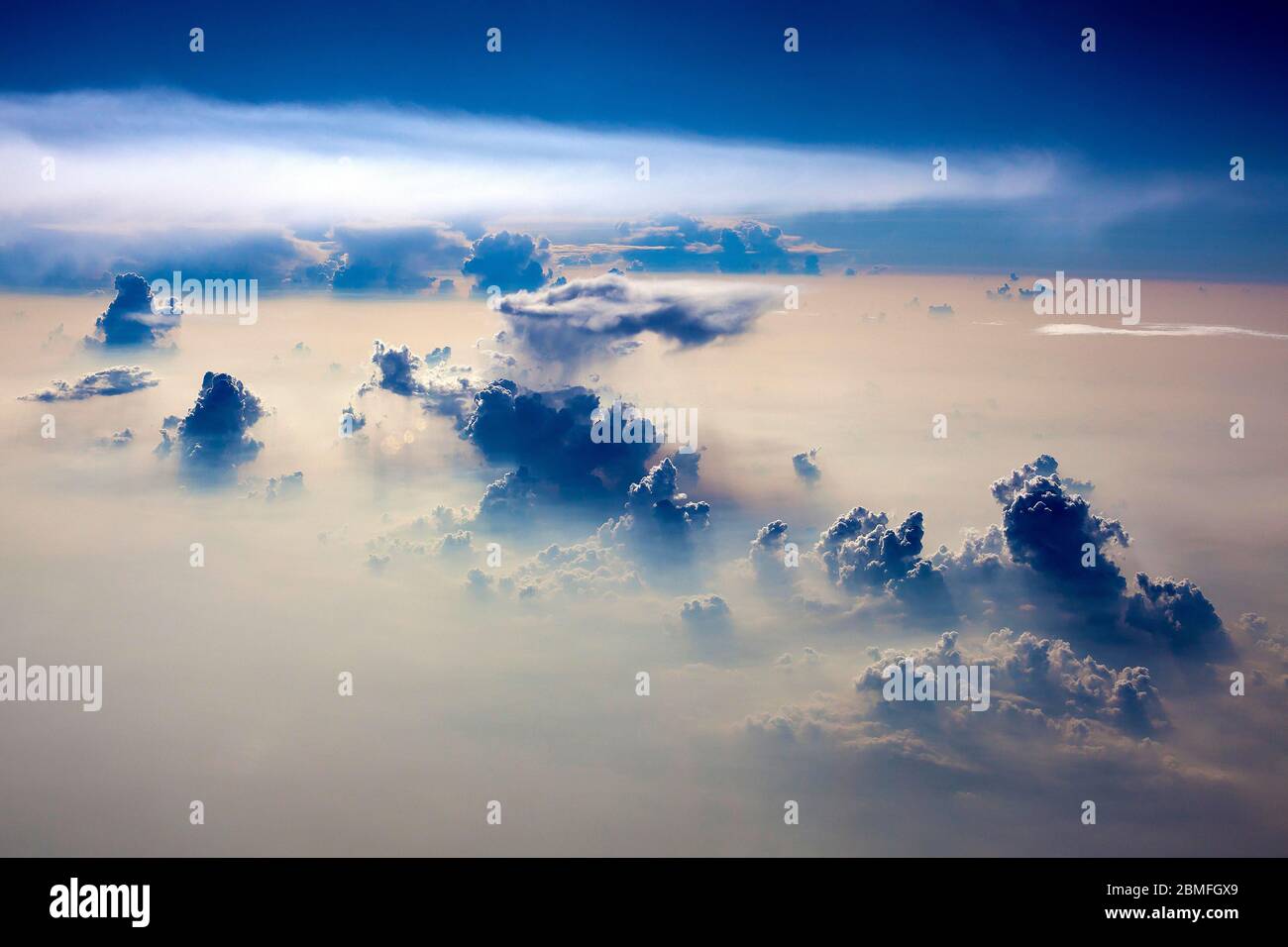 Clouds from above, flying over a polluted city. On a flight arriving to ...