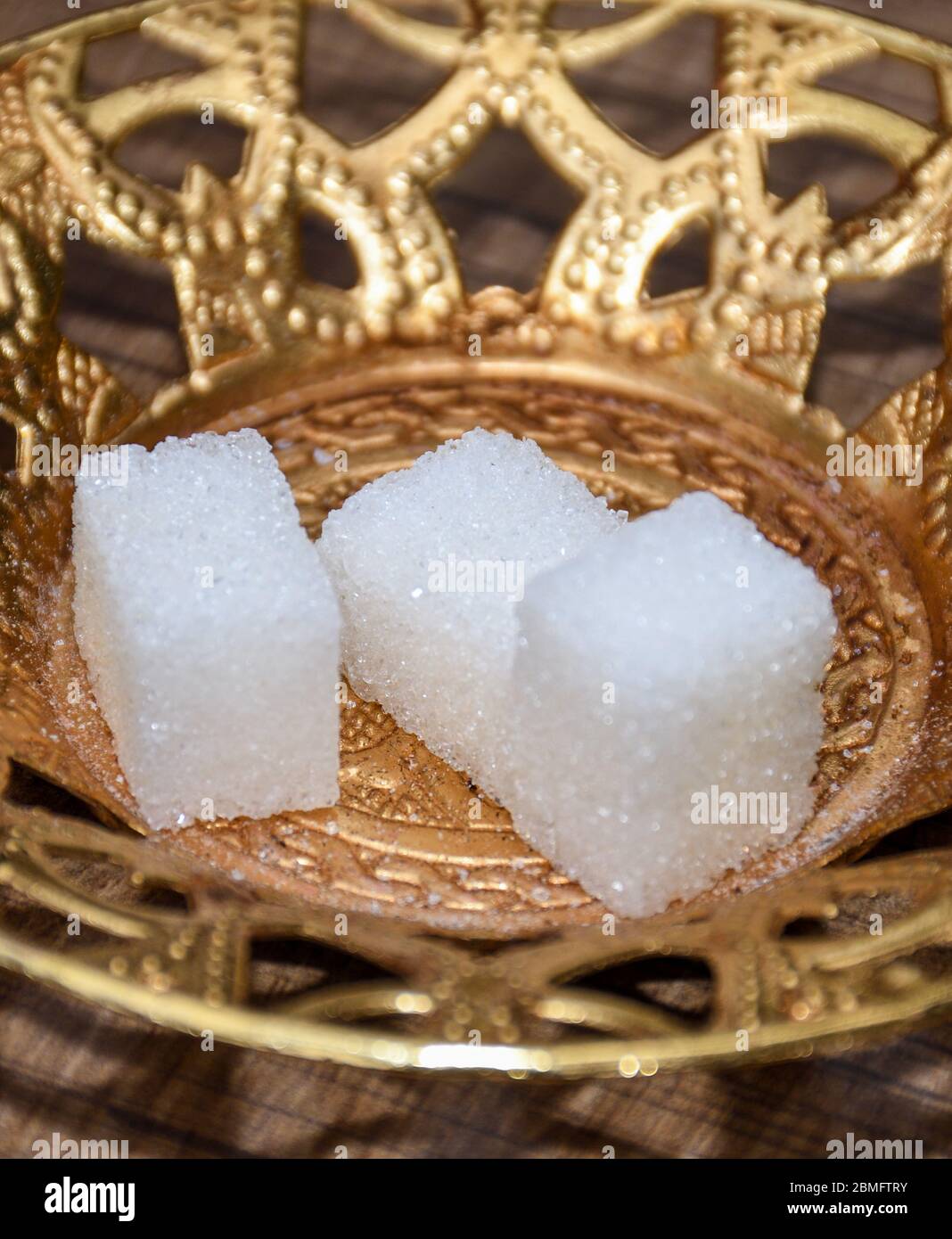 Three white sugar cubes isolated on goden turkish plate, for morning ...