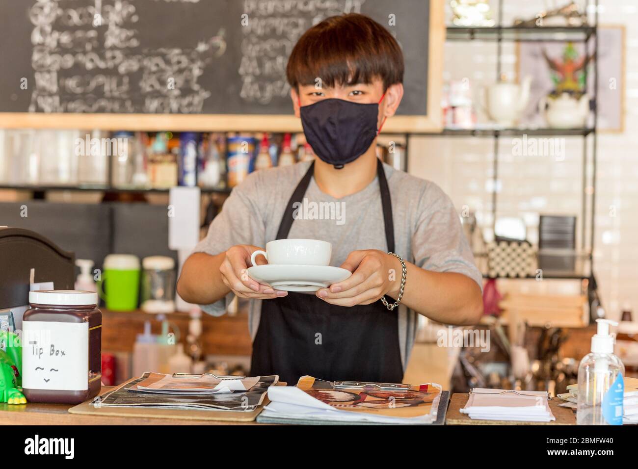 Social distance small business waiter serving coffee to customer in ...