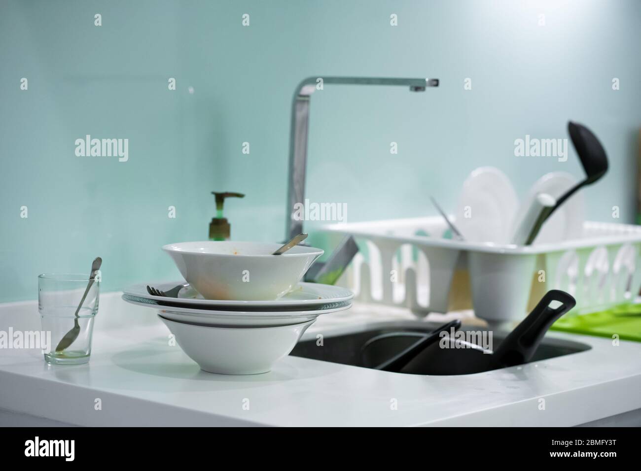 A mountain of dirty dishes in the kitchen sink. Mess in the house Stock ...