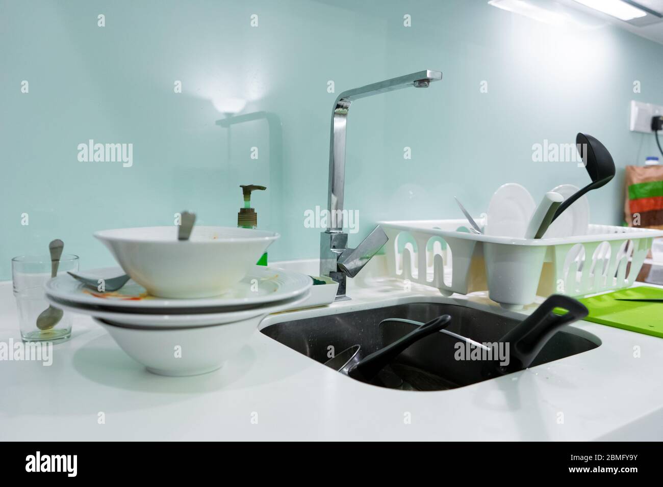 A mountain of dirty dishes in the kitchen sink. Mess in the house Stock ...