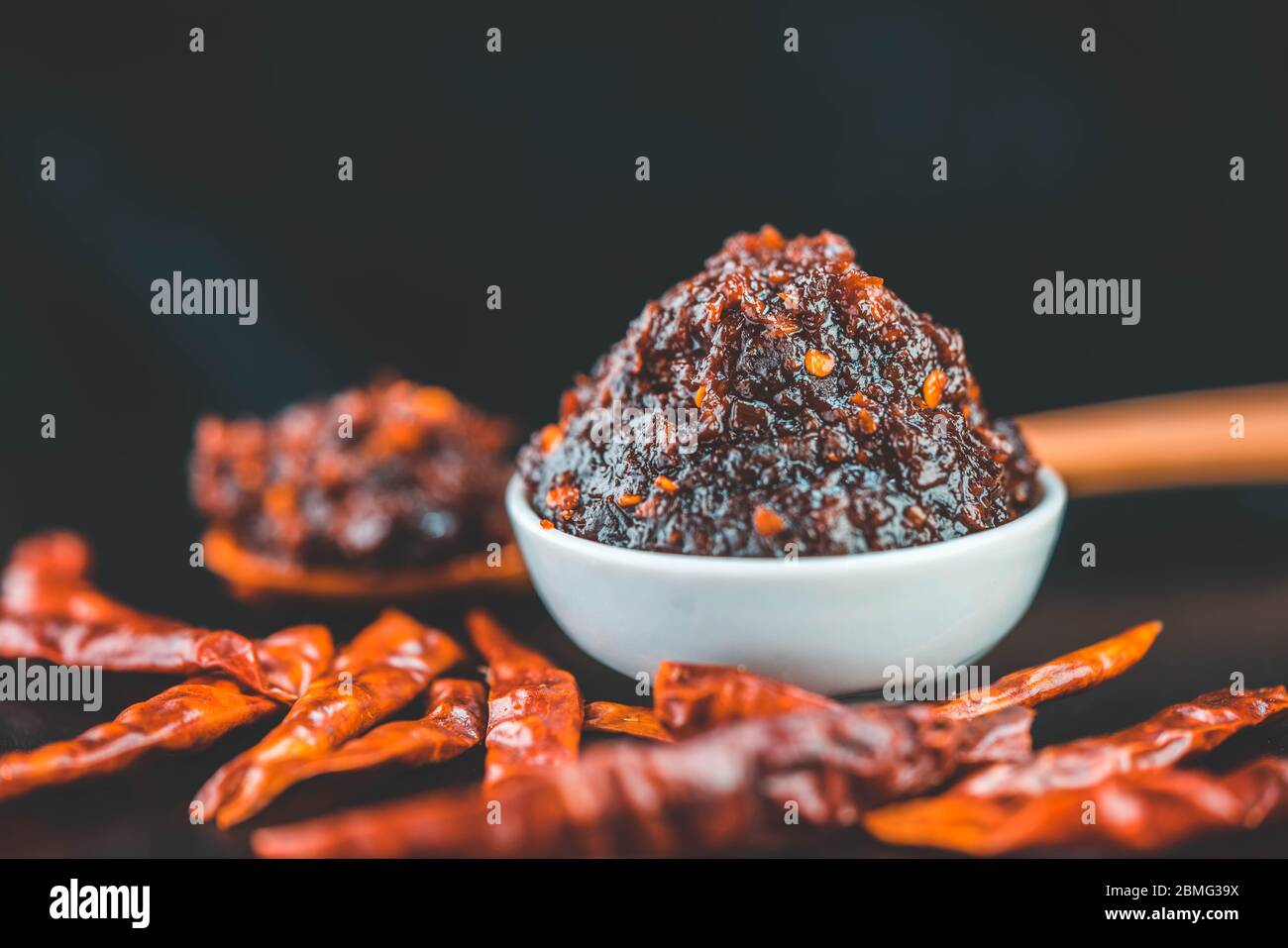 Spicy chili paste in white ceramic container on dark background Stock ...