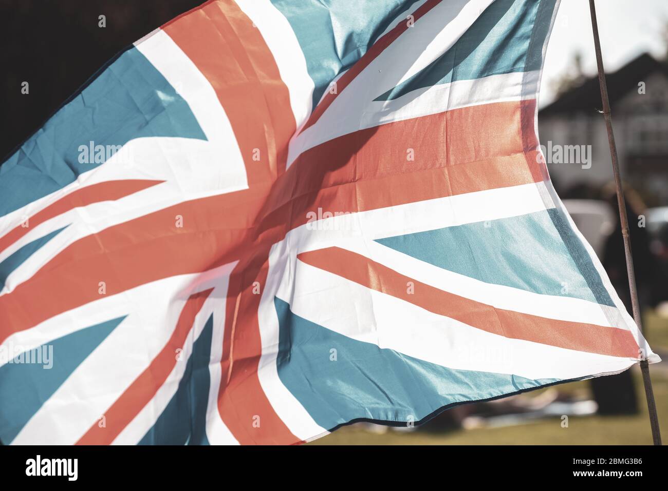 Union Jack flag flying in front of VE Day celebrations at a social ...