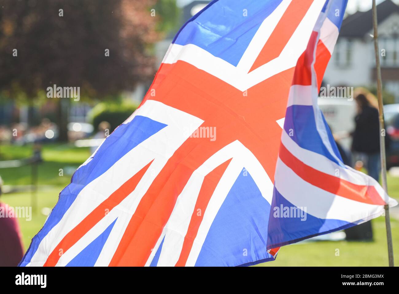 Union Jack flag flying in front of VE Day celebrations at a social ...