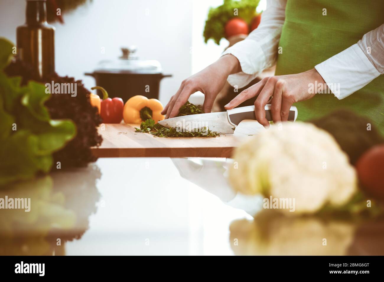 Unknown human hands cooking in kitchen. Woman is busy with vegetable ...