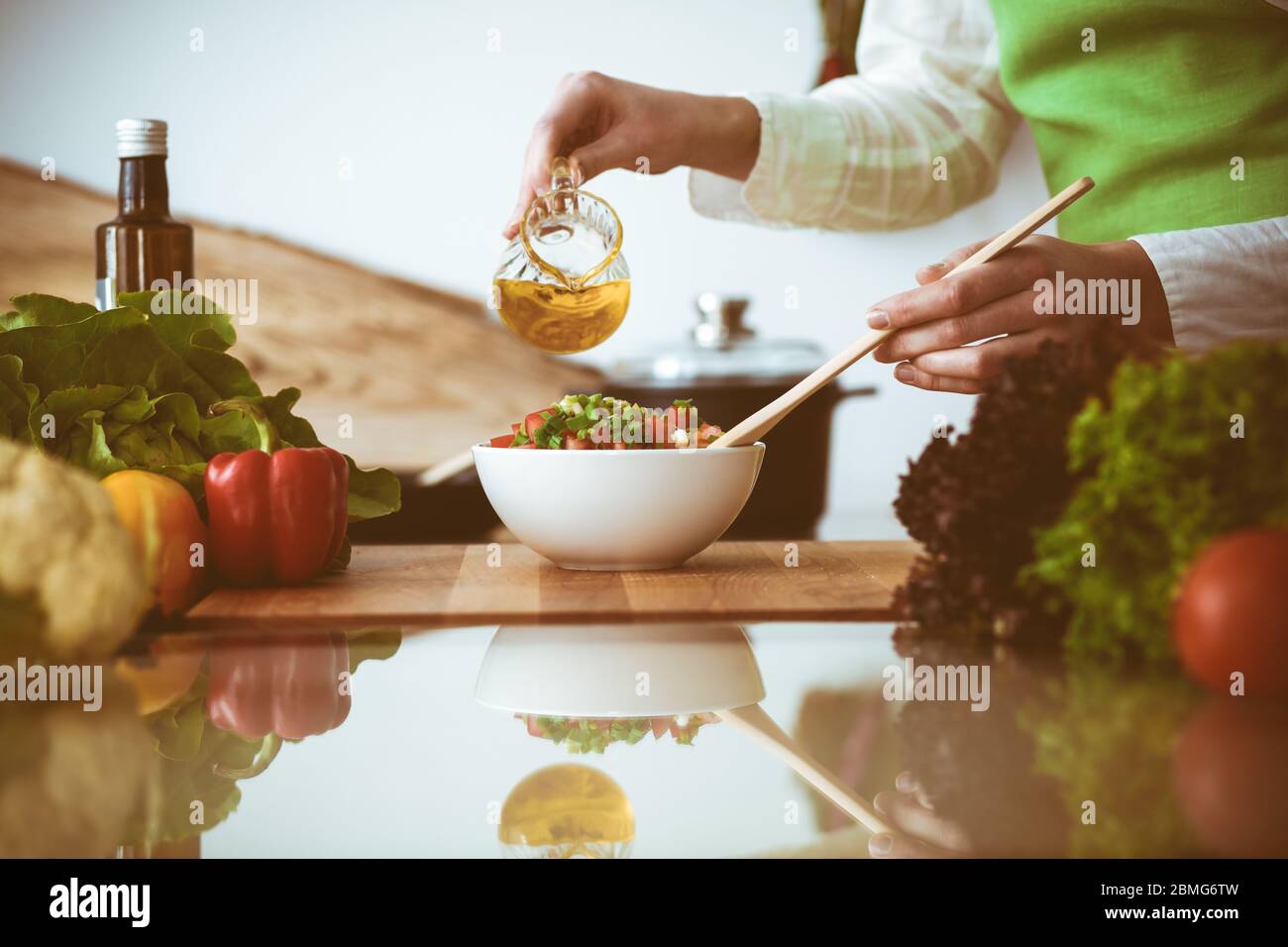 Unknown human hands cooking in kitchen. Woman is busy with vegetable ...