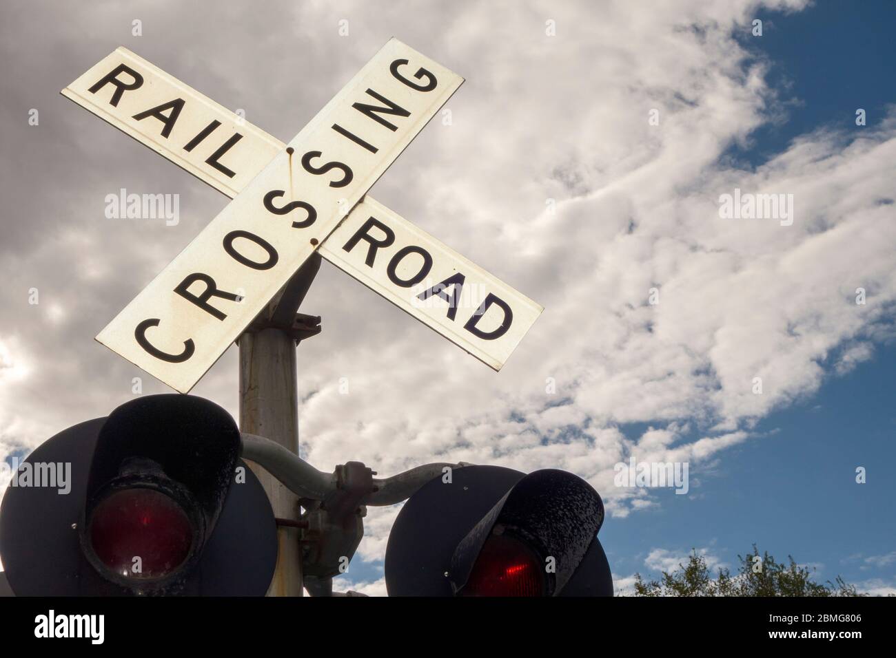 white and back text rail road crossing sign with big red lights on a ...