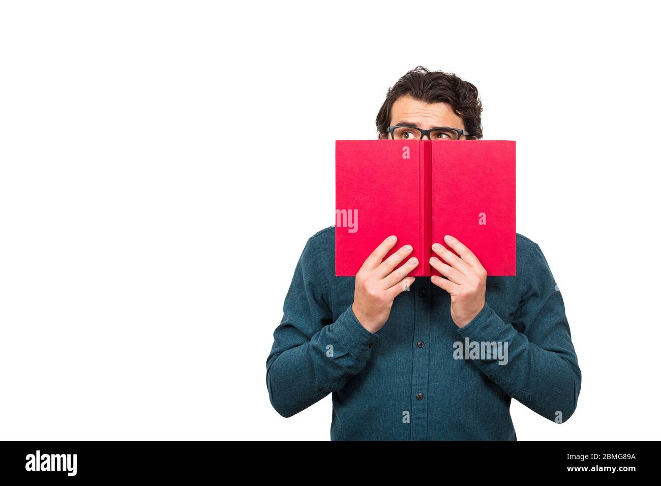 Student guy hiding behind a red book, looking suspicious aside isolated ...
