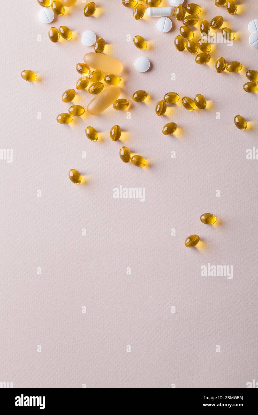 Natural vitamins and supplements on pink background. close up vertical ...
