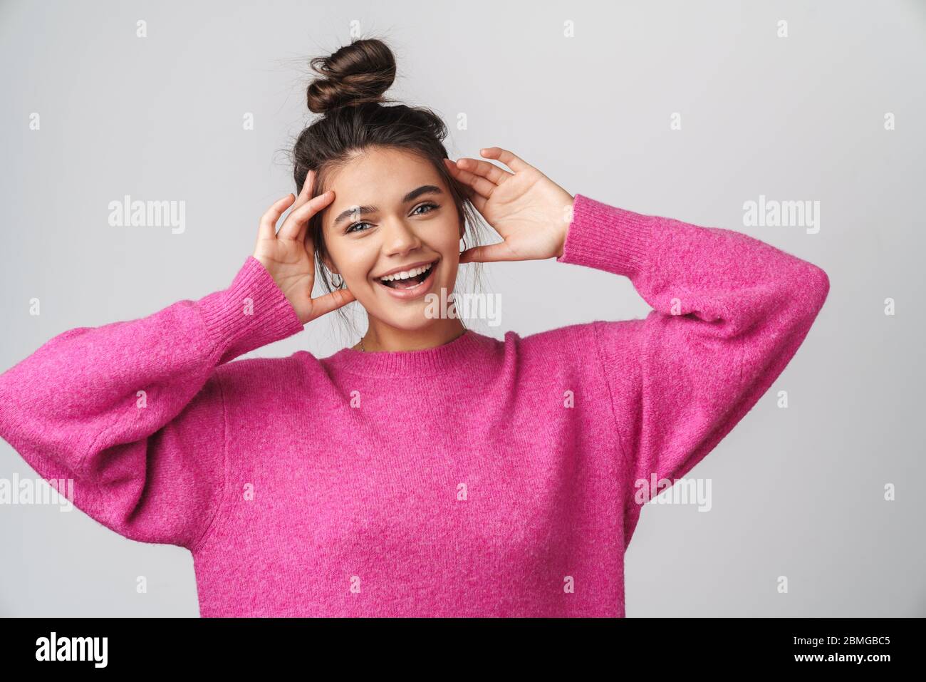 Image of nice joyful woman in pink sweater smiling and grabbing her ...