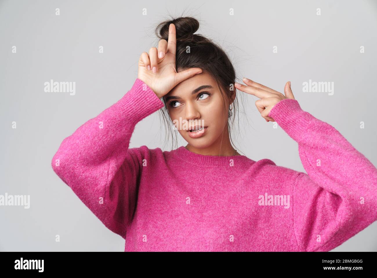 Image of nice young woman pointing finger upward and making gun gesture ...