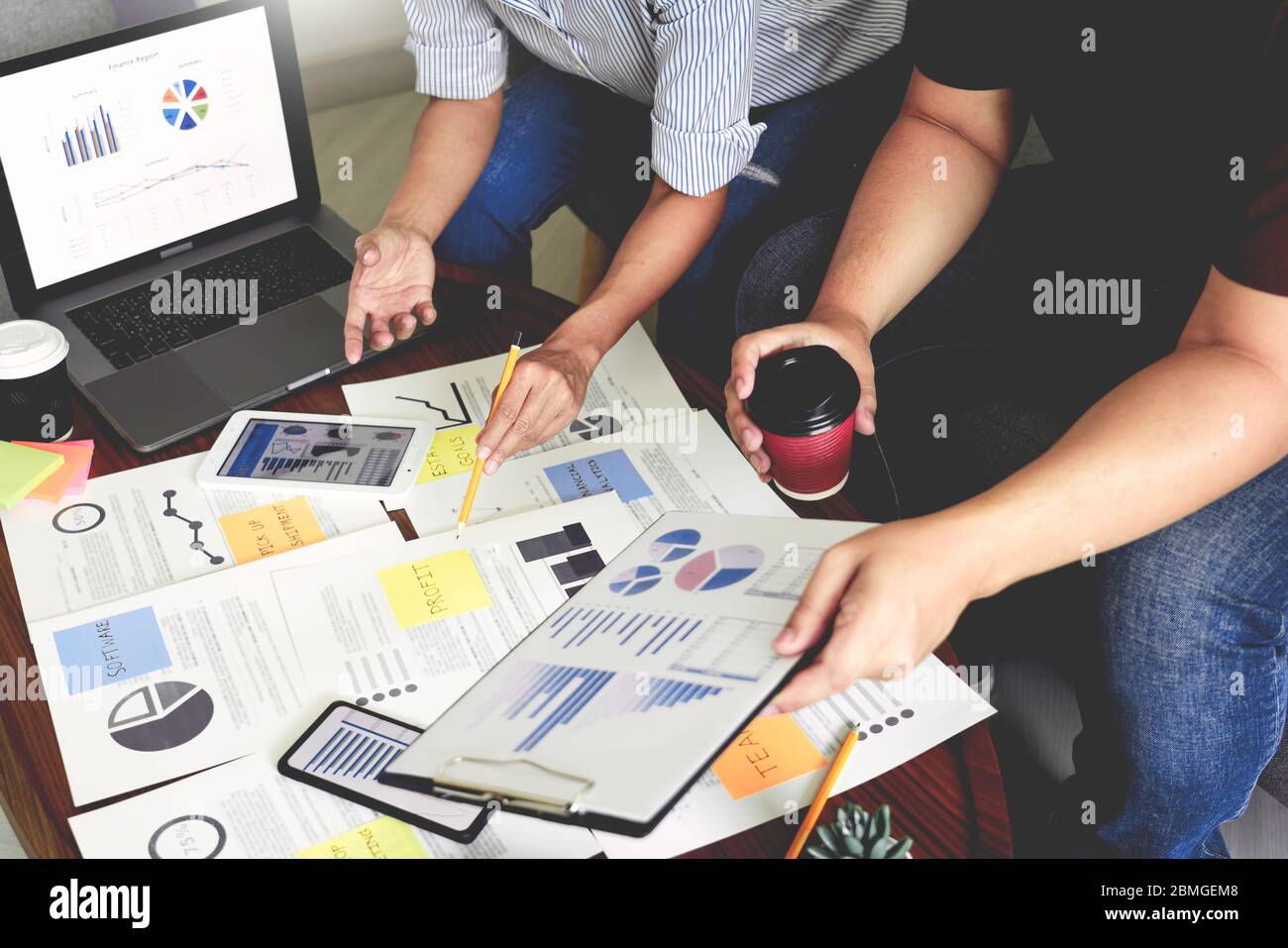 Business people writing on sticky notes for colleagues thinking ...