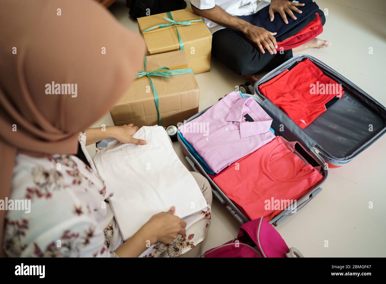 close up of hand packing on a suitcase at home Stock Photo - Alamy