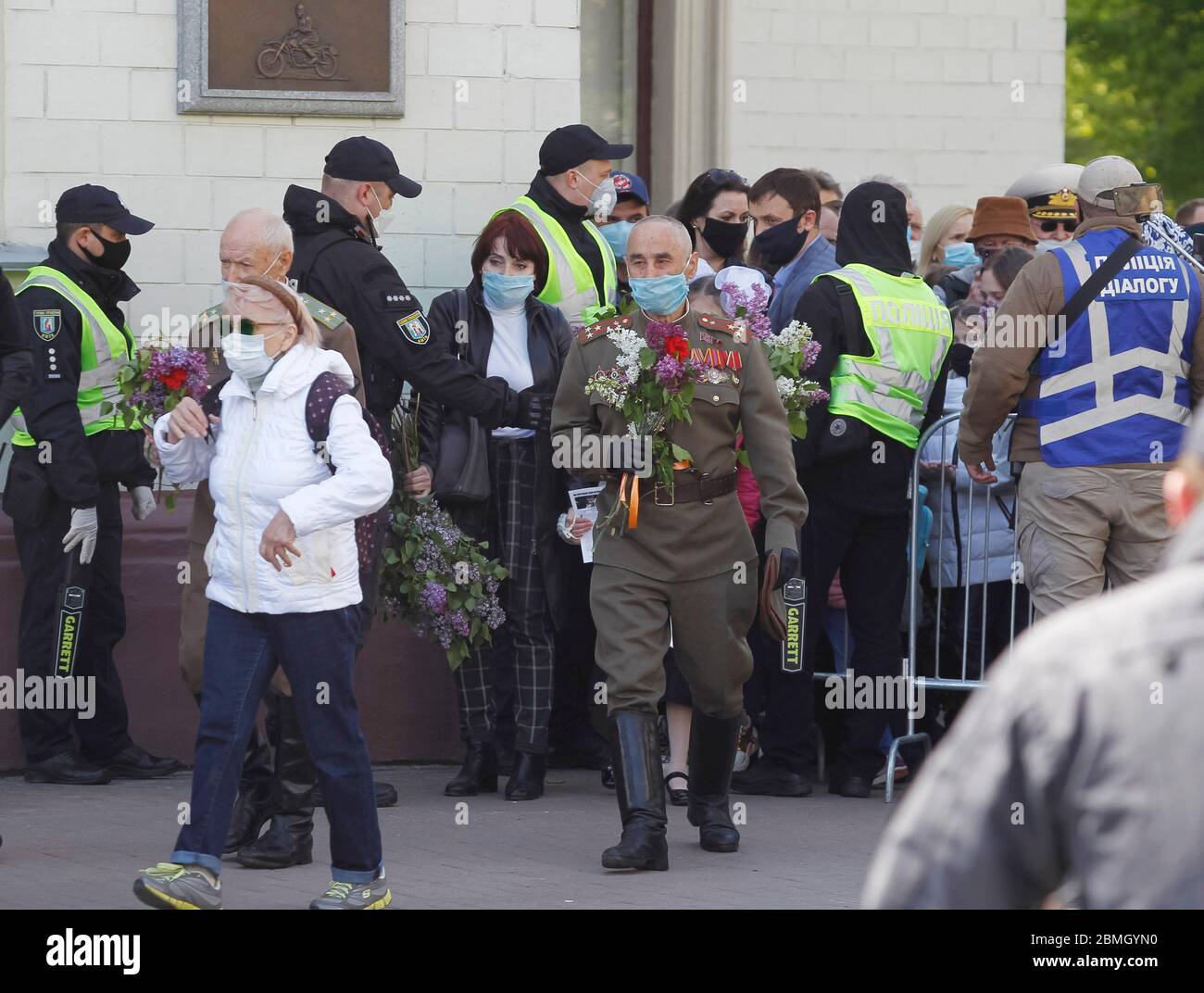 Kiev, Ukraine. 09th May, 2020. People carry flowers while wearing face ...