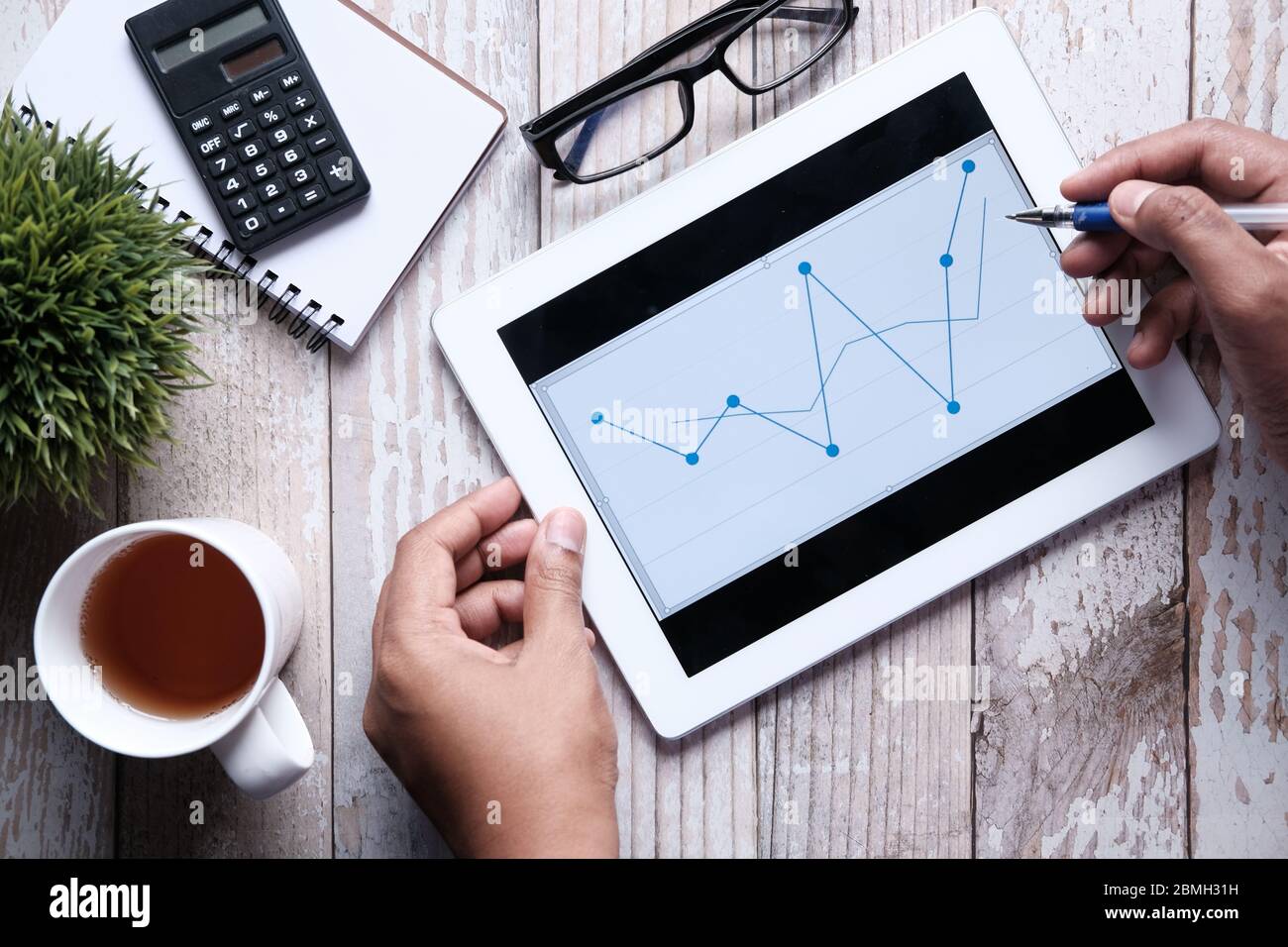 Top view of person hand analyzing charts on digital tablet, Using self ...