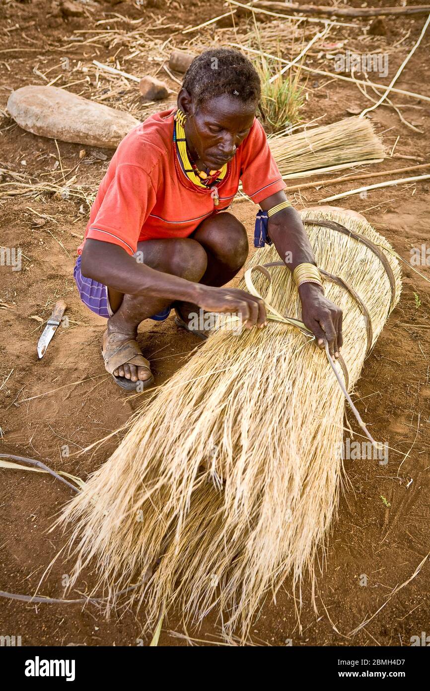 The Hamer Gele builds a beehive with peeled tree bark and straw on his ...