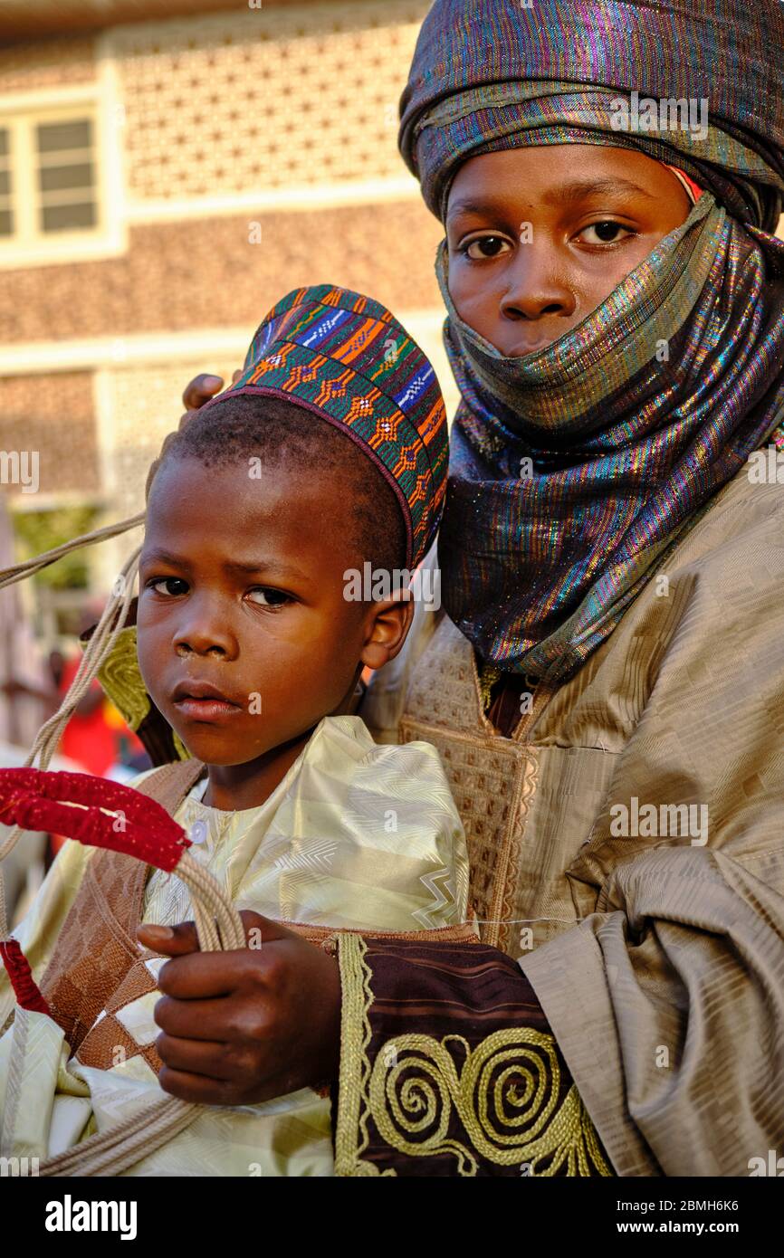 Noble children riders dressed in a colourful outfit mounting a horse ...