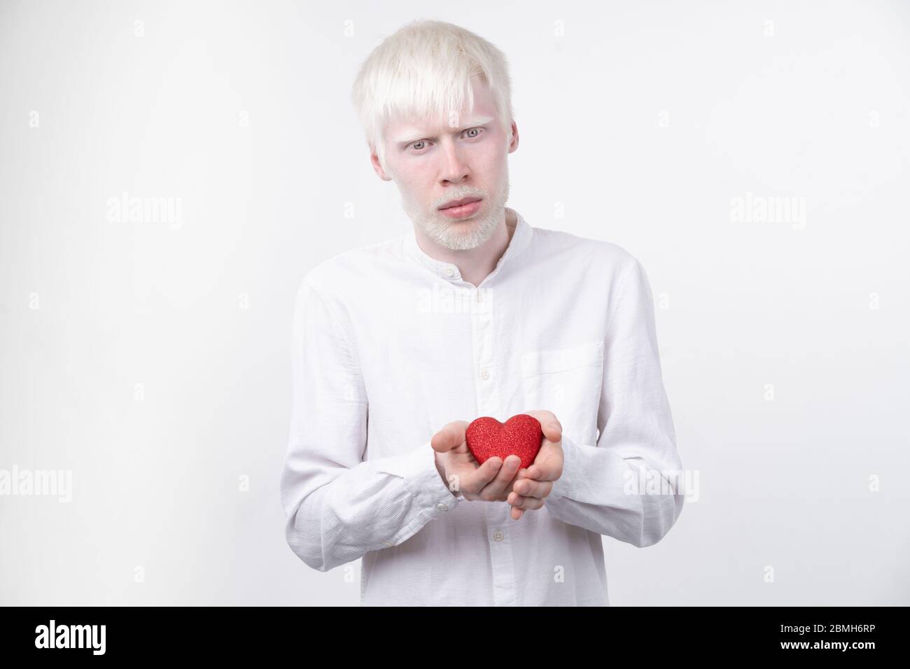 portrait of an albino man in studio dressed t-shirt isolated on a white ...