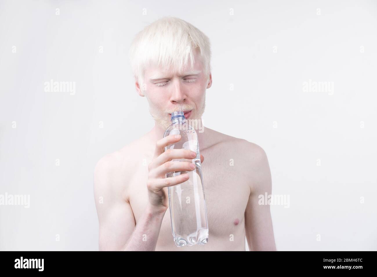 portrait of an albino man in studio dressed t-shirt isolated on a white ...