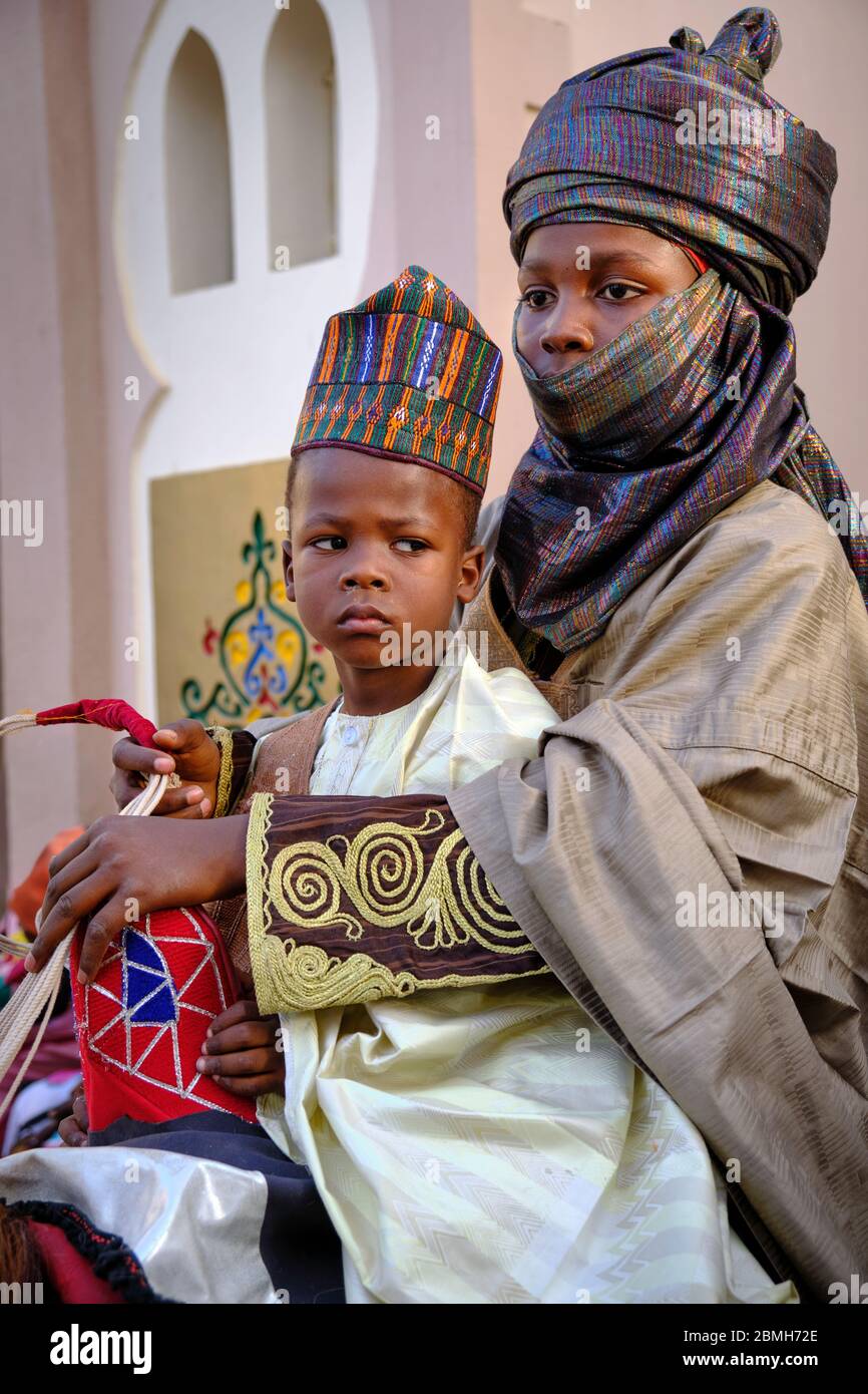 Noble children riders dressed in a colourful outfit mounting a horse ...