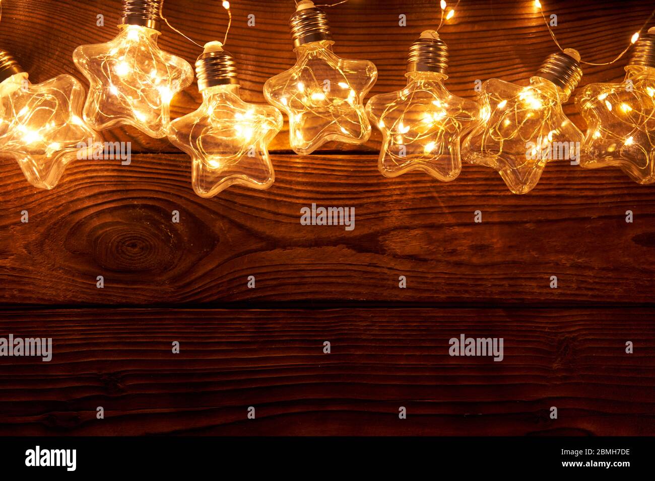 Bright luminous Christmas garlands in the shape of stars lie on a dark ...