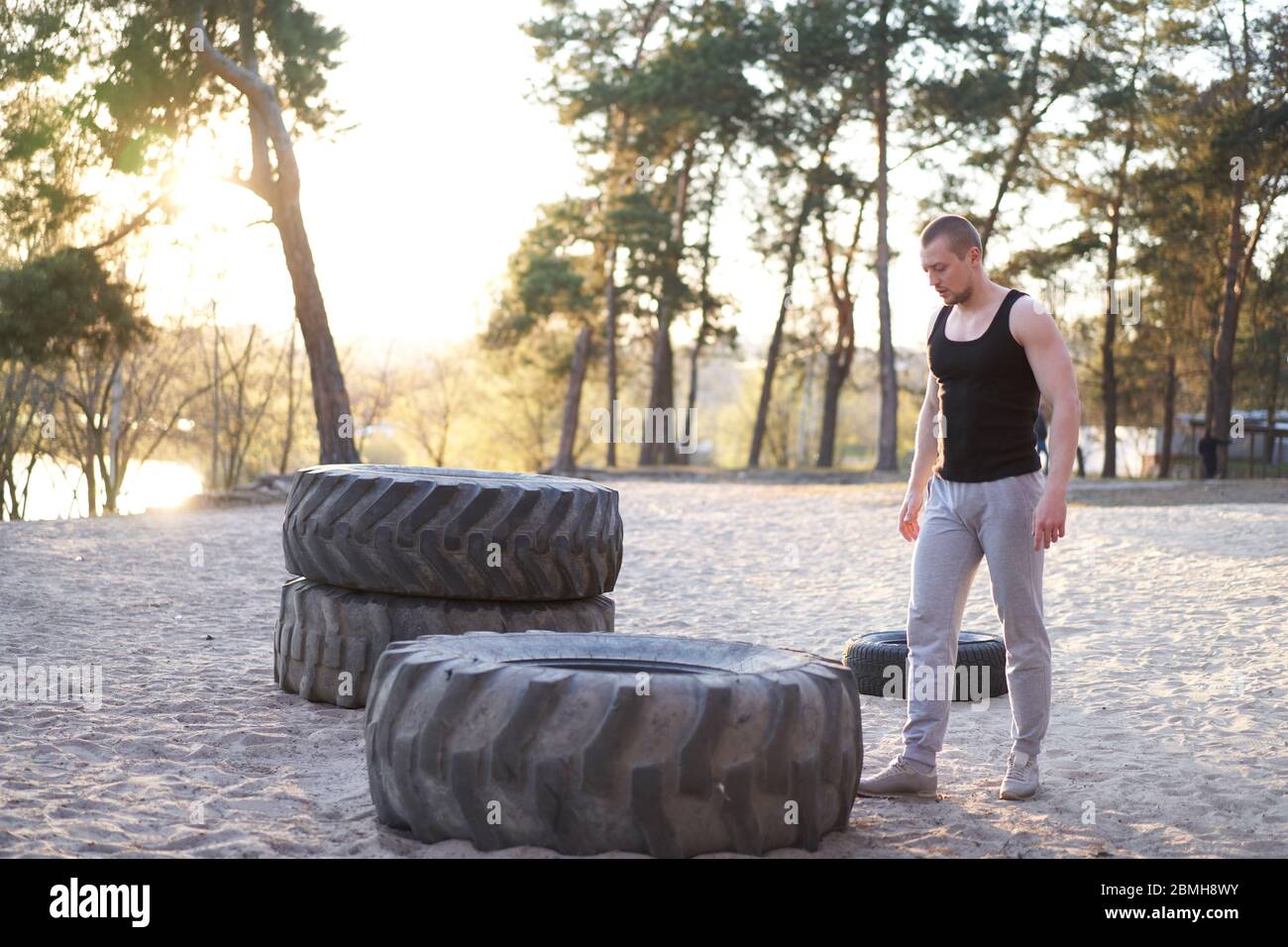 Strong man training workout lifting large tire outdoor DIY gym ...