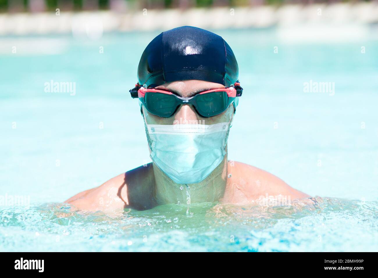Masked man swimming in a pool, coronavirus pandemic sport concept Stock ...