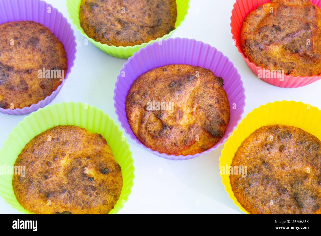 Homemade chocolate muffins in multi-colored silicone cups close-up on a ...