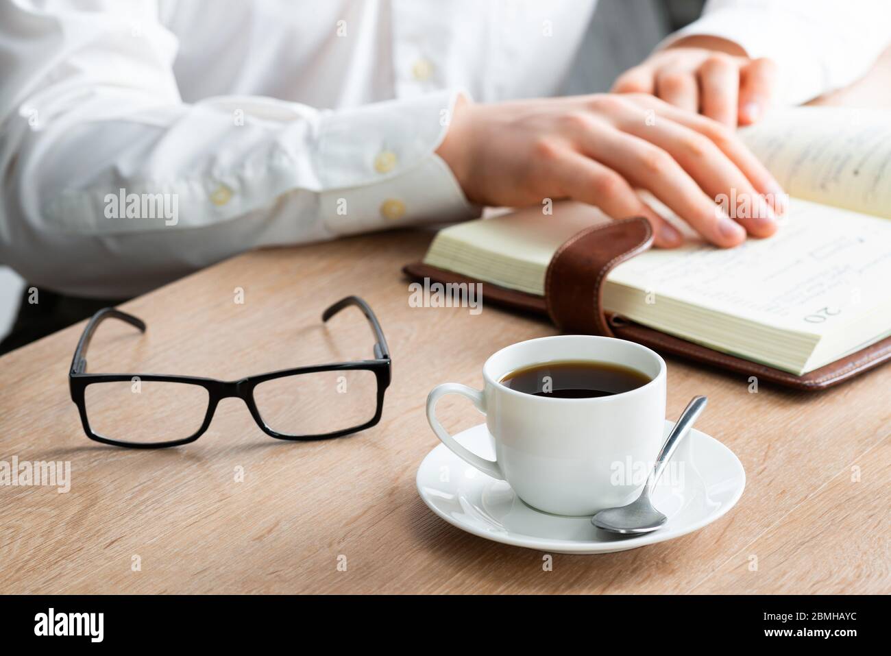 Man in white shirt reading notes in notebook Stock Photo - Alamy