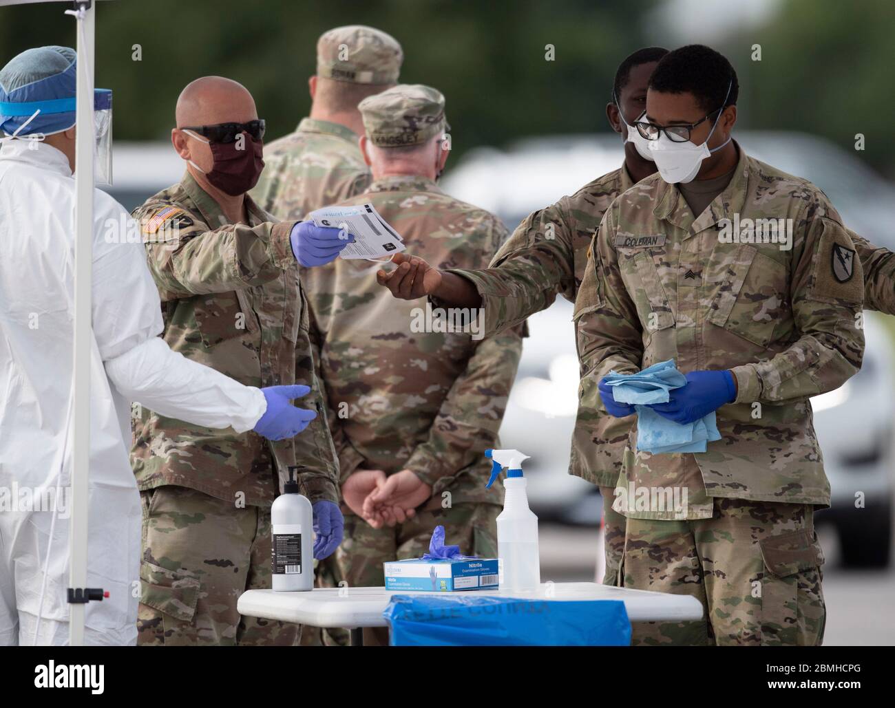 Spc. Nicholas Cisneros hands over a nasal swab taken from a patient as ...
