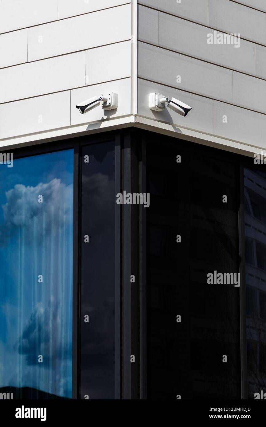 Two CCTV security surveillance cameras mounted on a corner of a modern ...