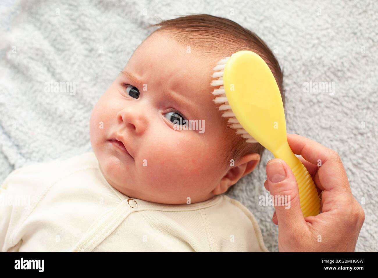 Hand brushing a baby's hair with a soft brush. Baby hygiene Stock Photo ...