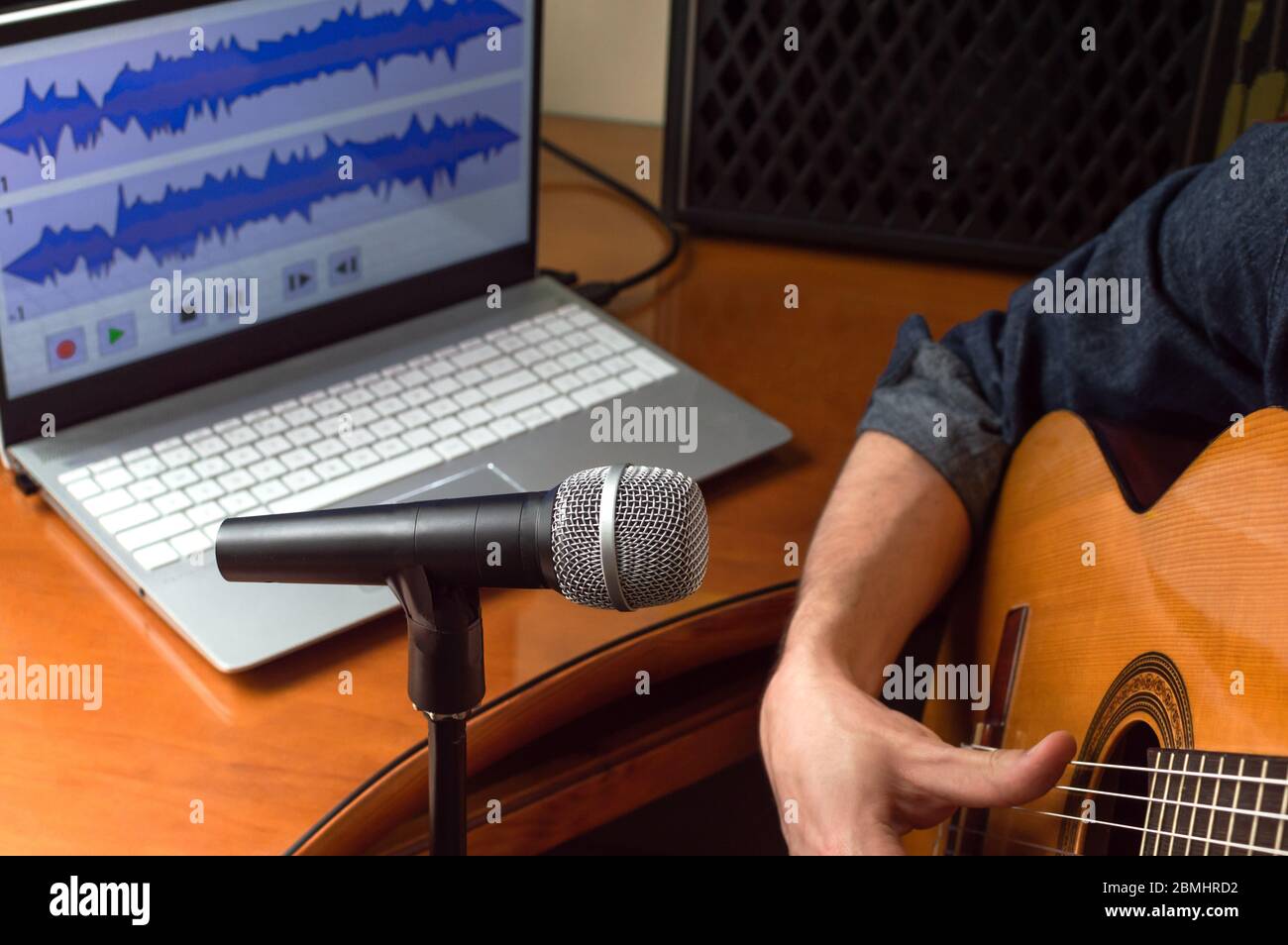 Person recording a song played on the guitar using microphone and ...